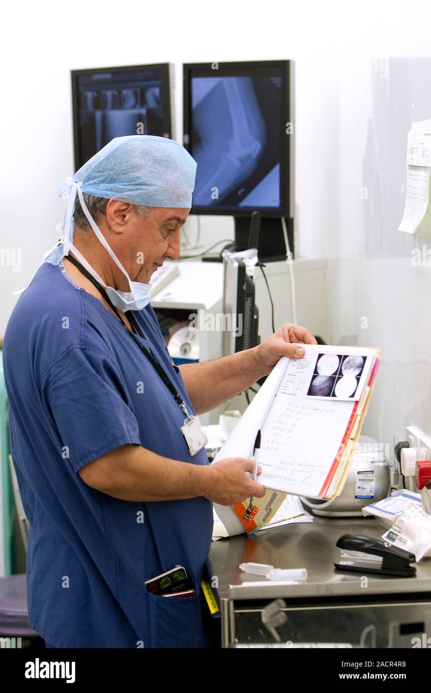 Surgeon reading a patient's notes Stock Photo - Alamy