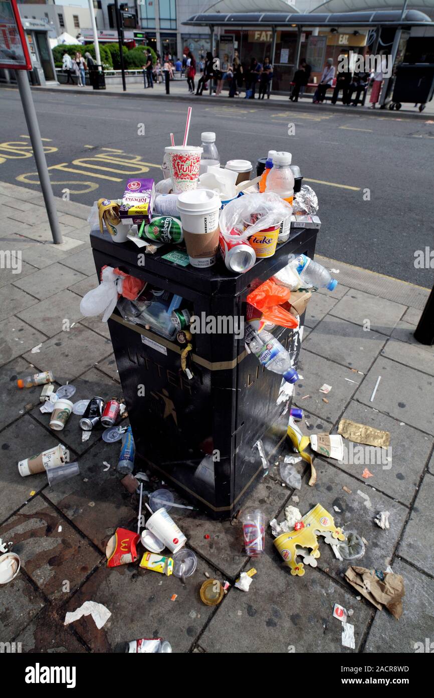 Overflowing litter bin. Photographed by a bus stop in the city centre ...