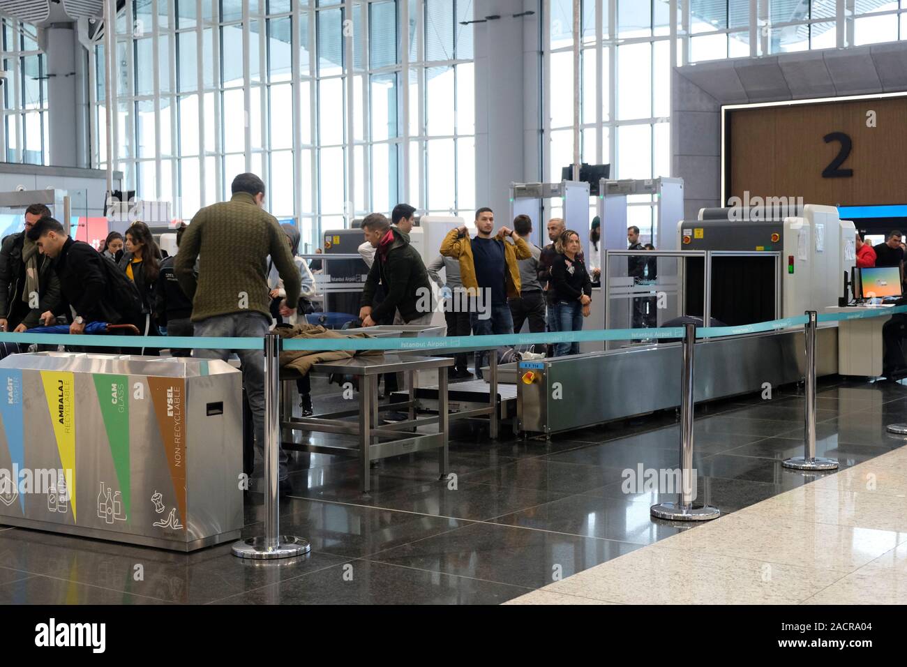 Passengers put their luggage through x-ray screening equipment at a ...
