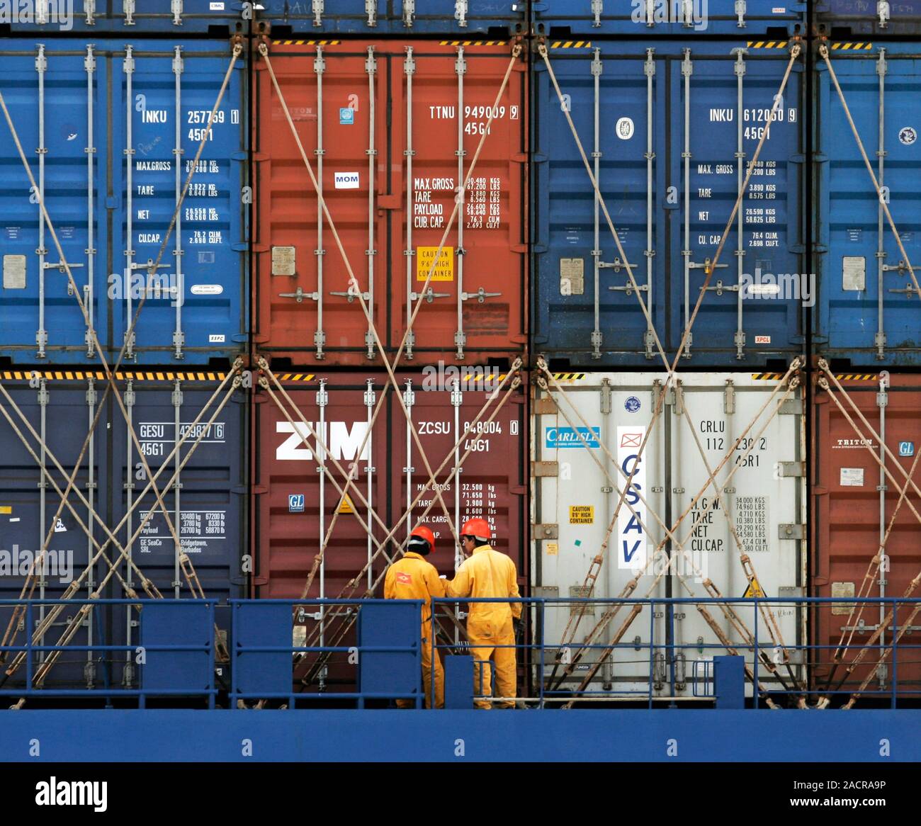 Container port. Workers checking shipping containers loaded onto the ...