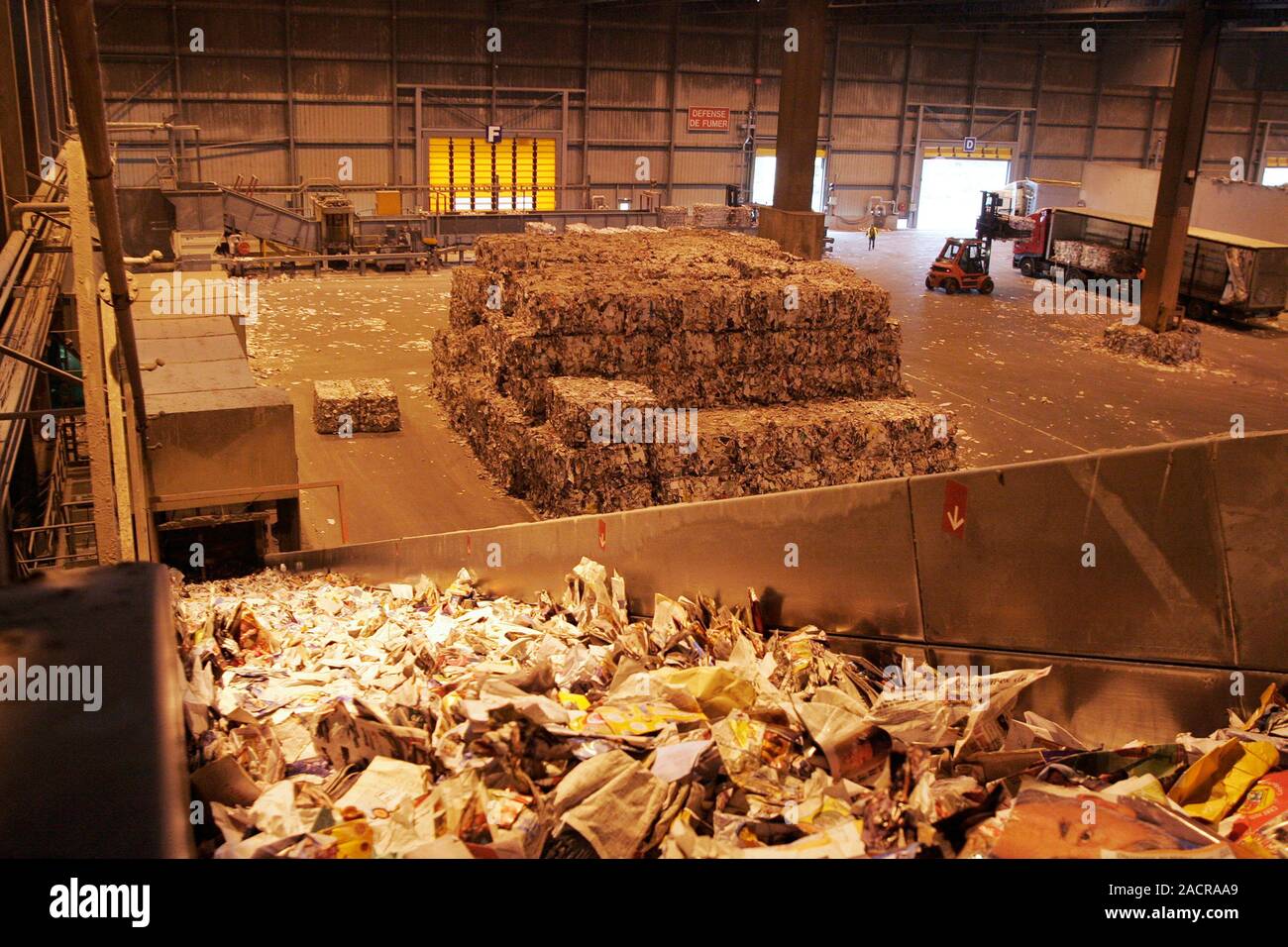 Paper mill. Waste paper being sorted and formed into bales to be ...