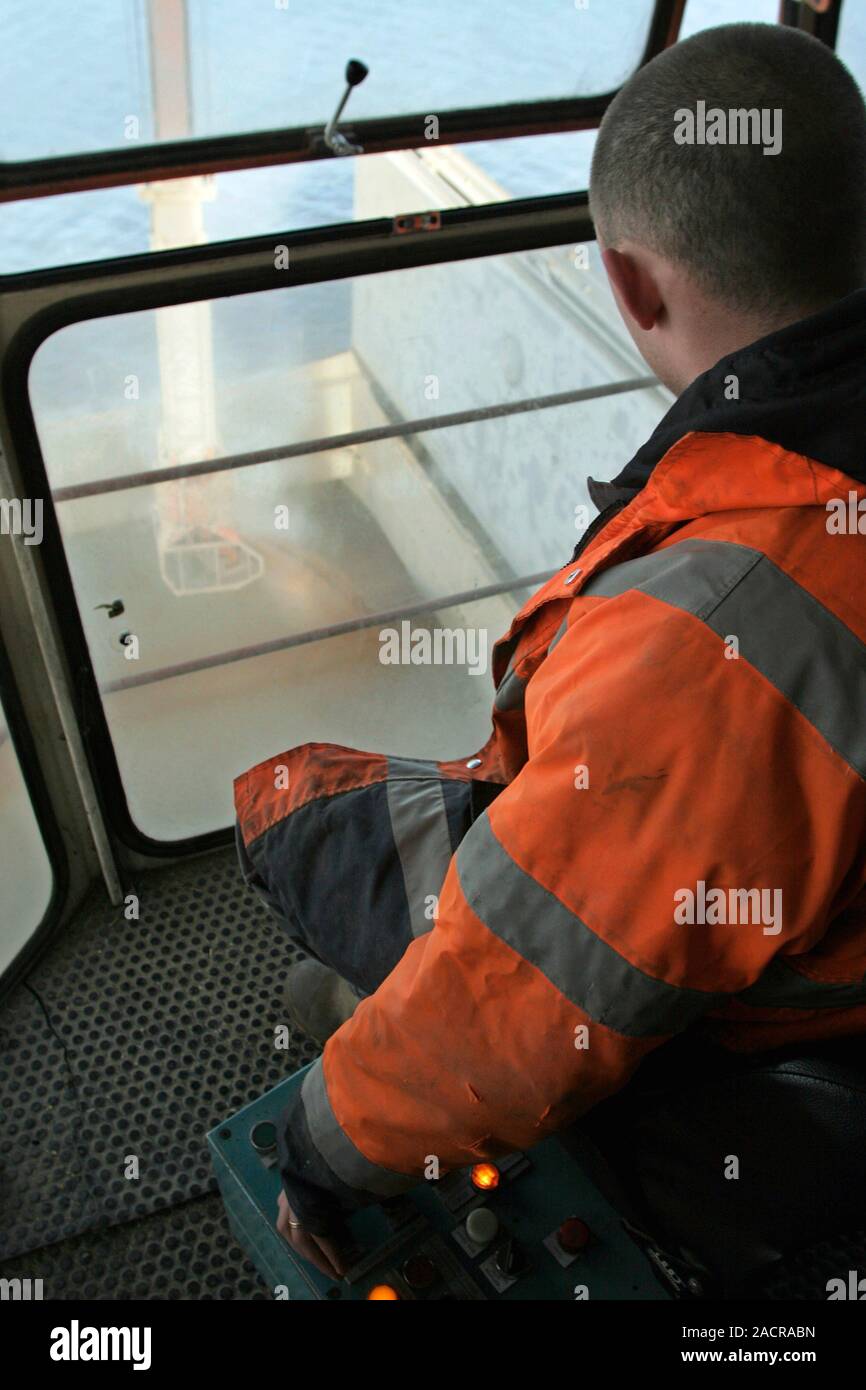 Grain cargo port. Machine operator controlling a loading device to fill ...