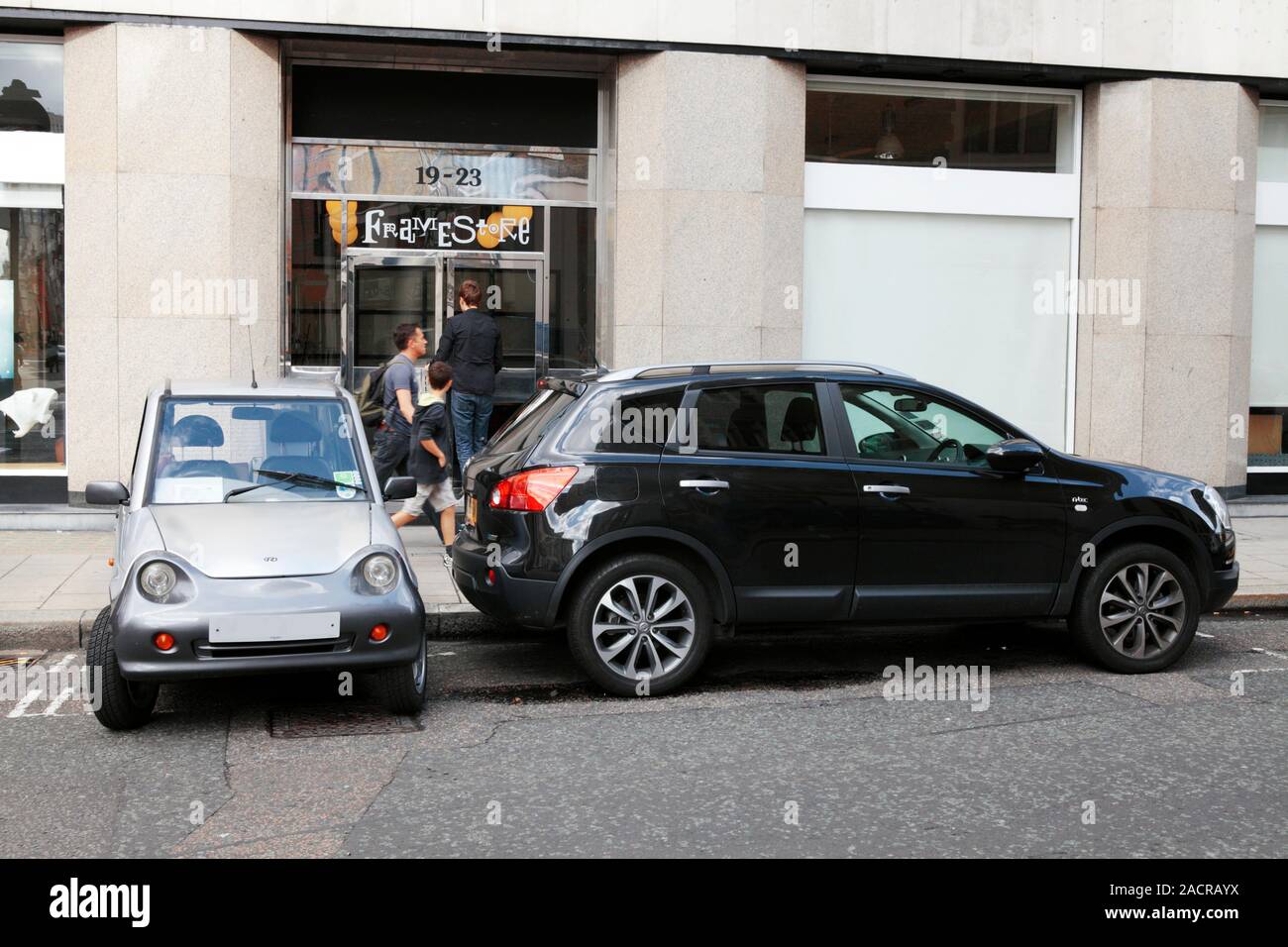 Electric car. Electric car (left) parked at right angles to the curb ...