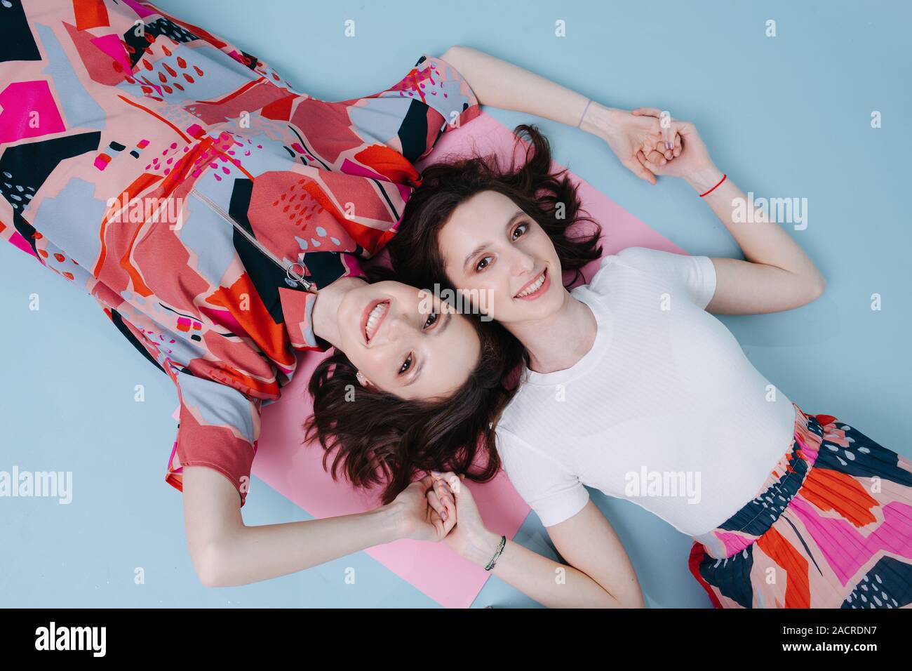 Twin sisters holding hands pink hi-res stock photography and images - Alamy