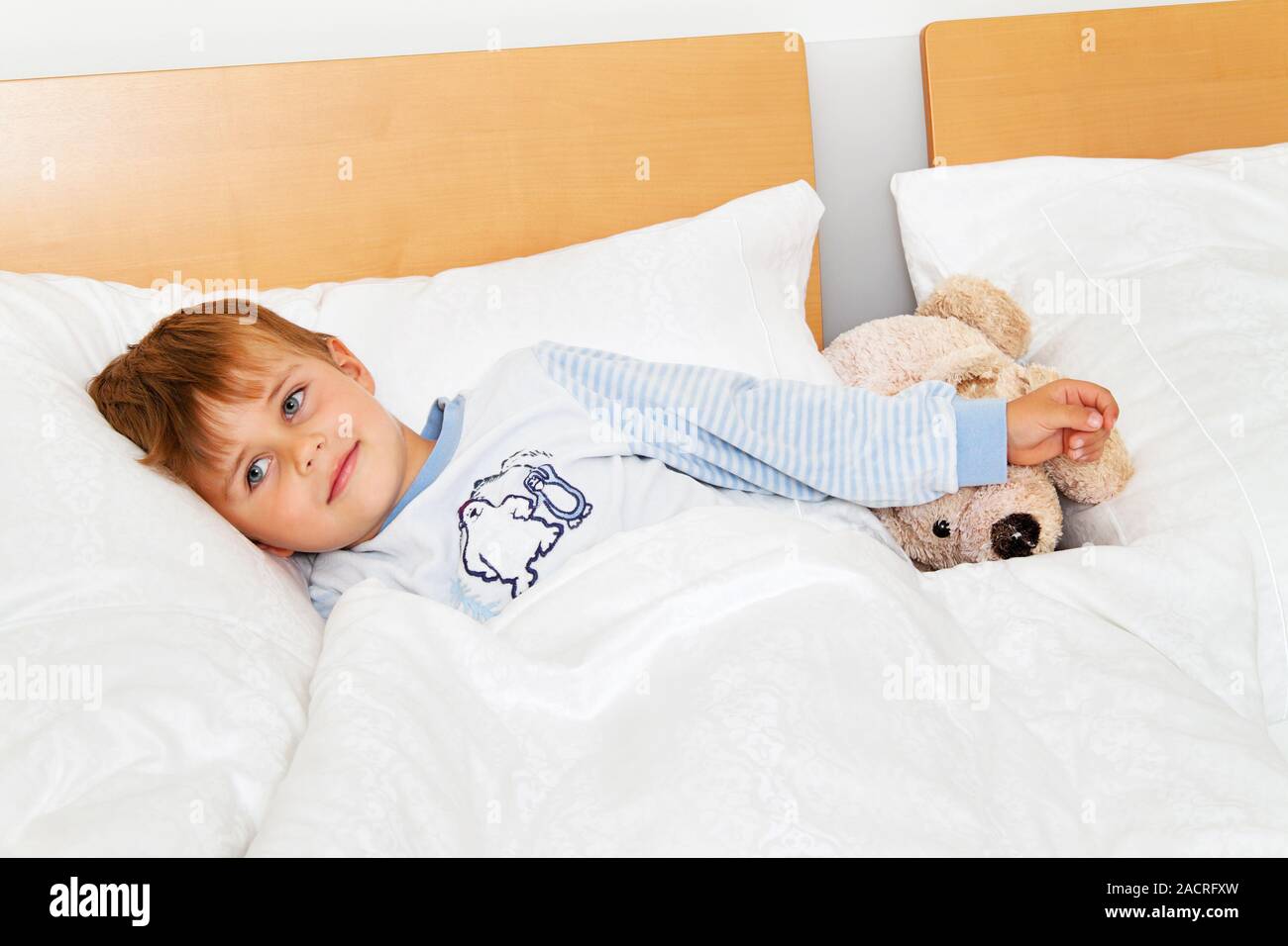 Child lying in bed in bedroom Stock Photo - Alamy