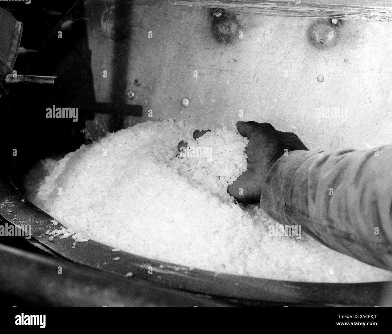 Nylon production. Factory worker's hand handling flakes of nylon at ...