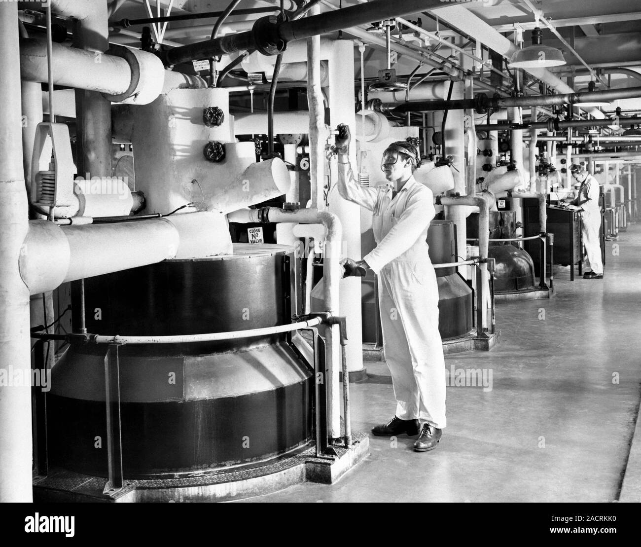 Nylon production. Workers operating polymerization autoclaves in a ...