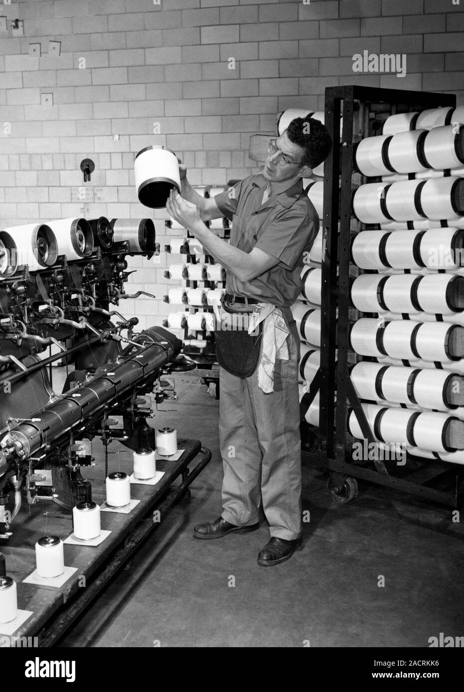 Nylon production. Factory worker carrying out sizing of new nylon yarn ...