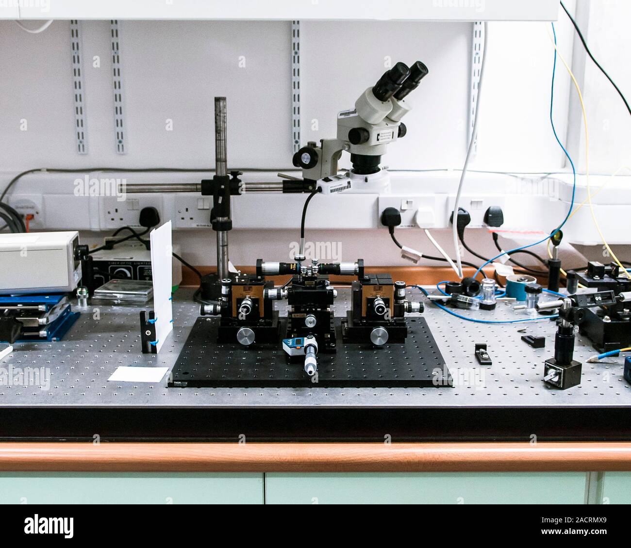 Optoelectronics research. Microscope and laser being used in ...