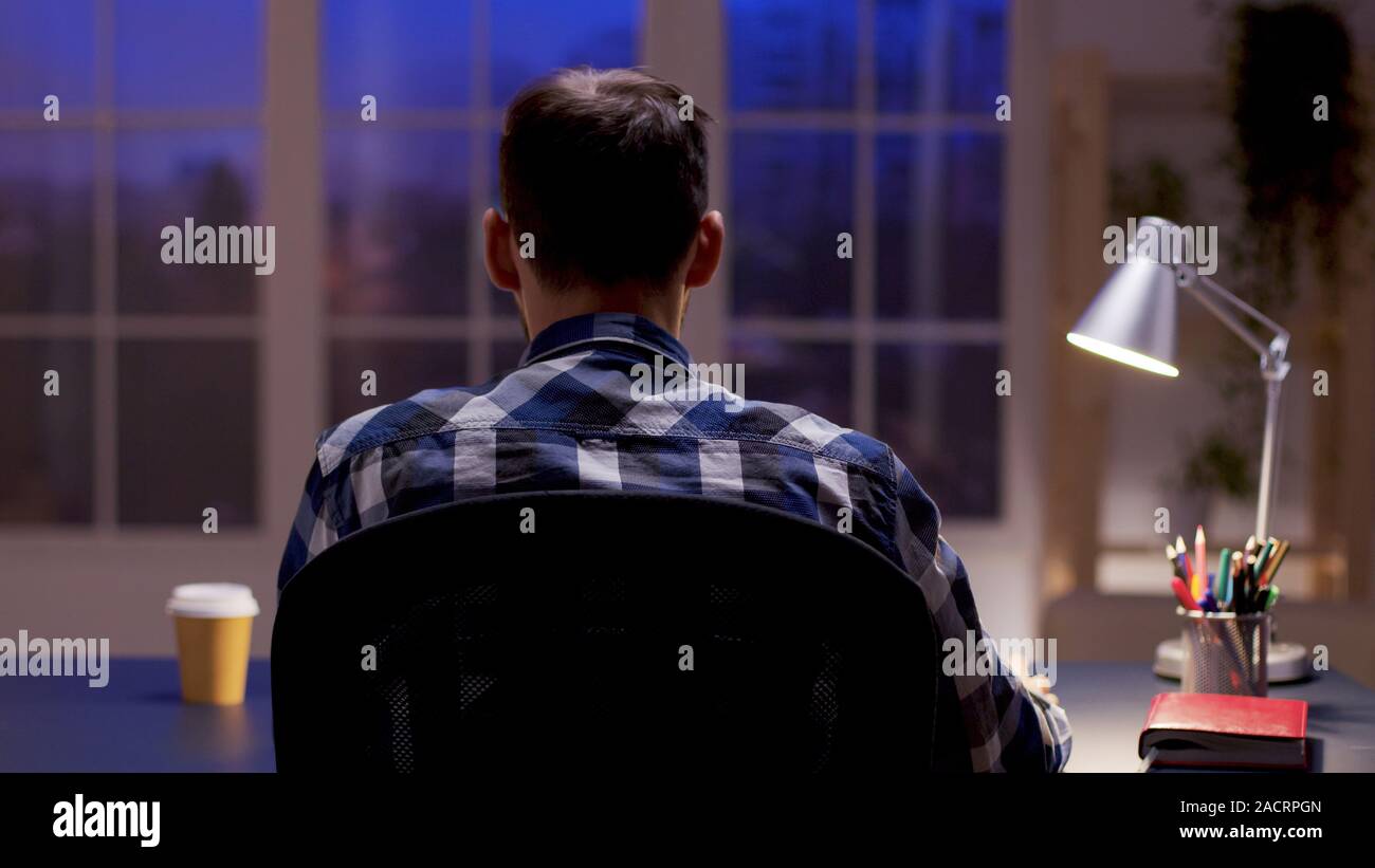 Back view of film editor working from home office at night hours Stock ...
