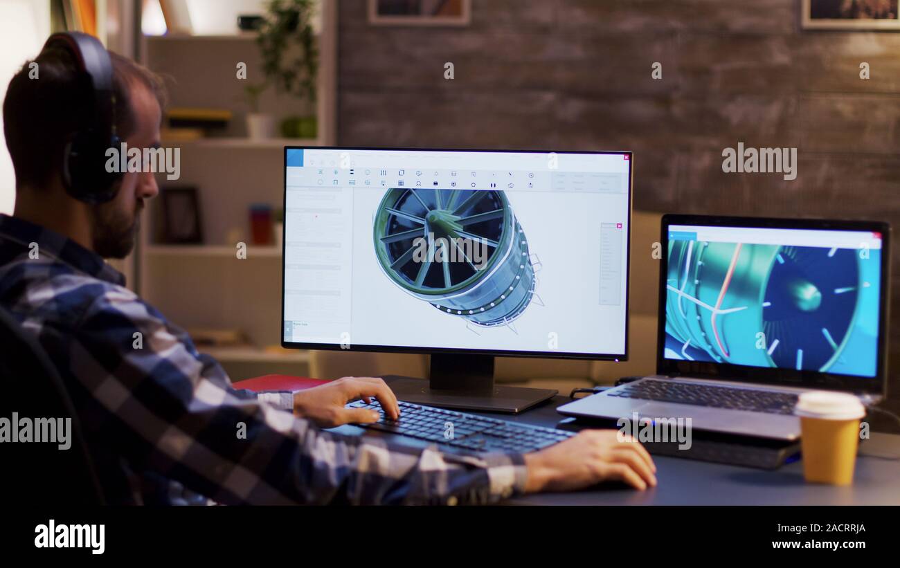Side view of engineer wearing headphones and working on a turbine using ...