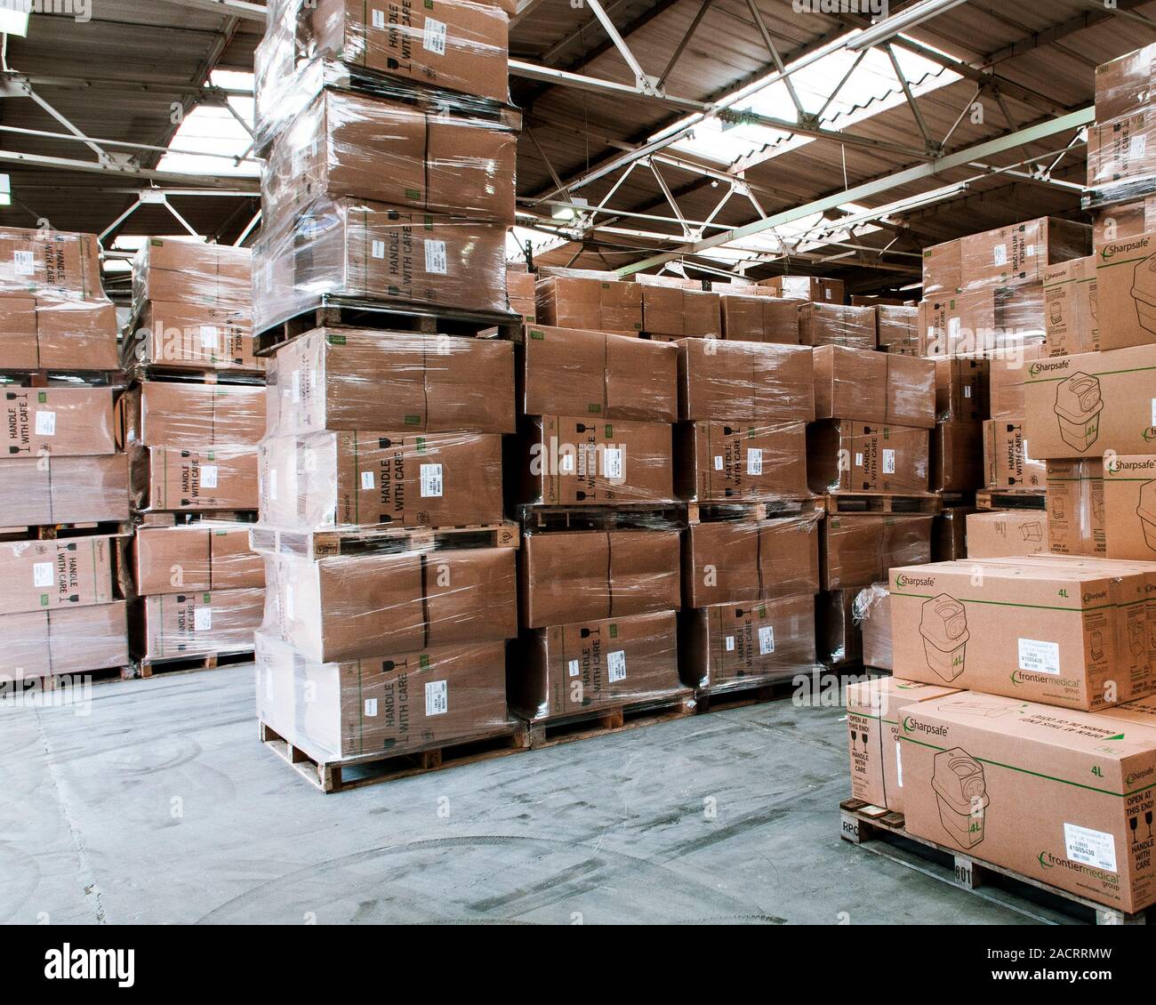 Factory warehouse. Cellophane-wrapped boxes on pallets in a factory ...