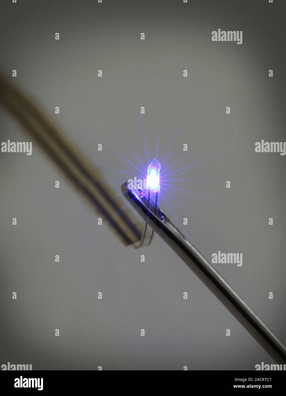 Miniature implantable LED light. A thin ribbon containing electrodes ...