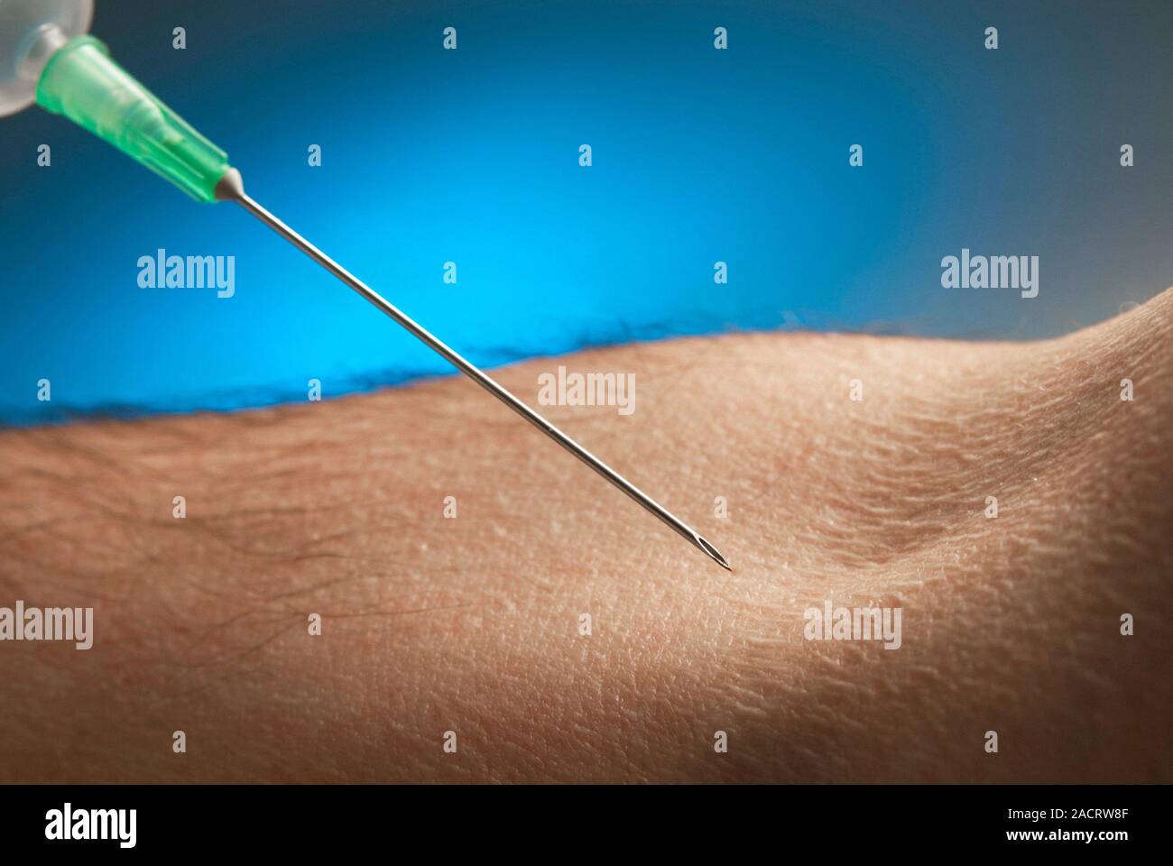 Injection. Needle about to inject a person's arm Stock Photo - Alamy