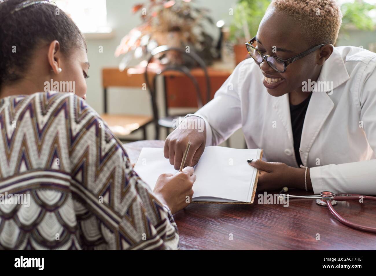 patient girl Mexican signs a treatment agreement with a black woman ...