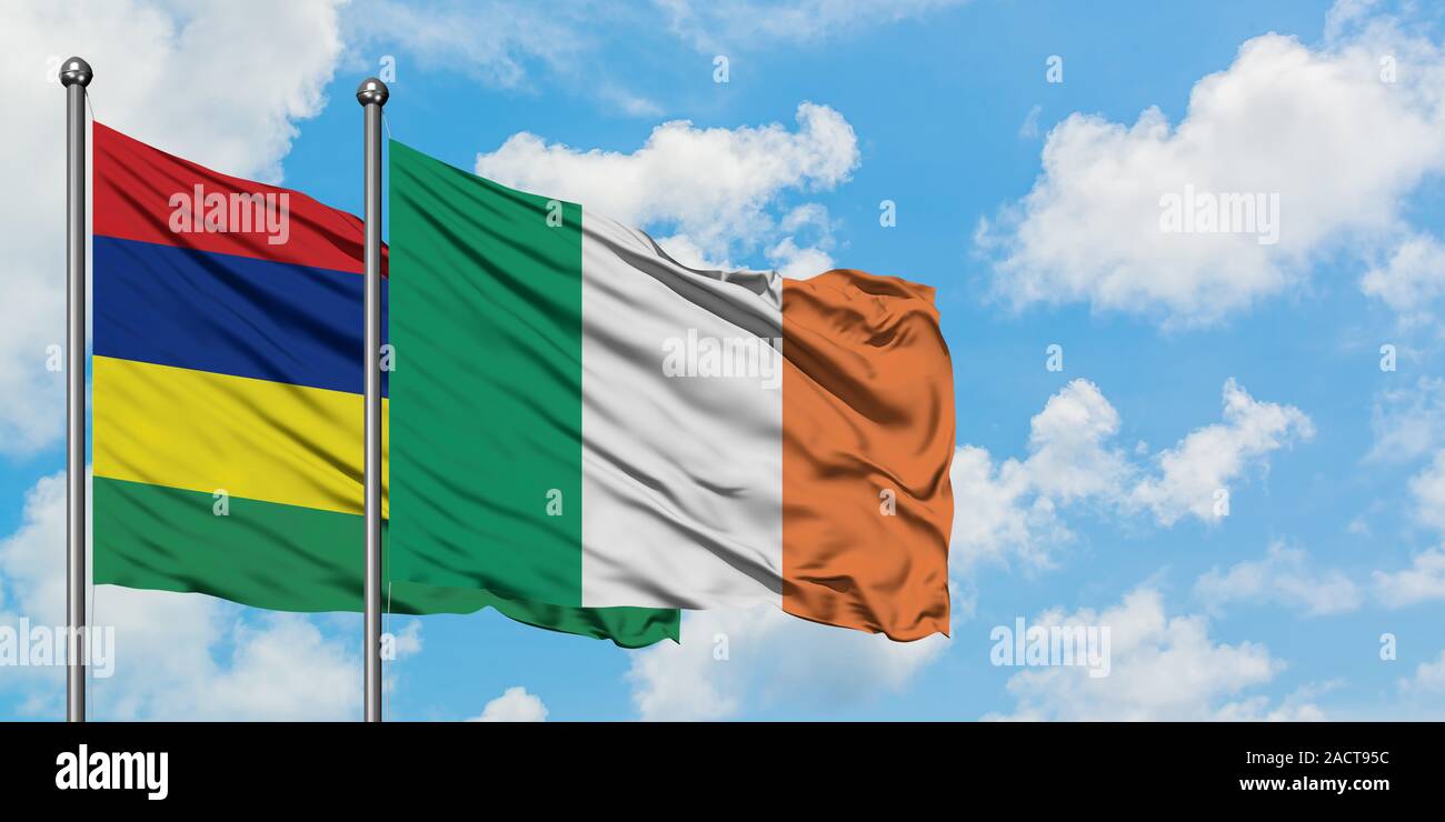 Mauritius and Ireland flag waving in the wind against white cloudy blue ...