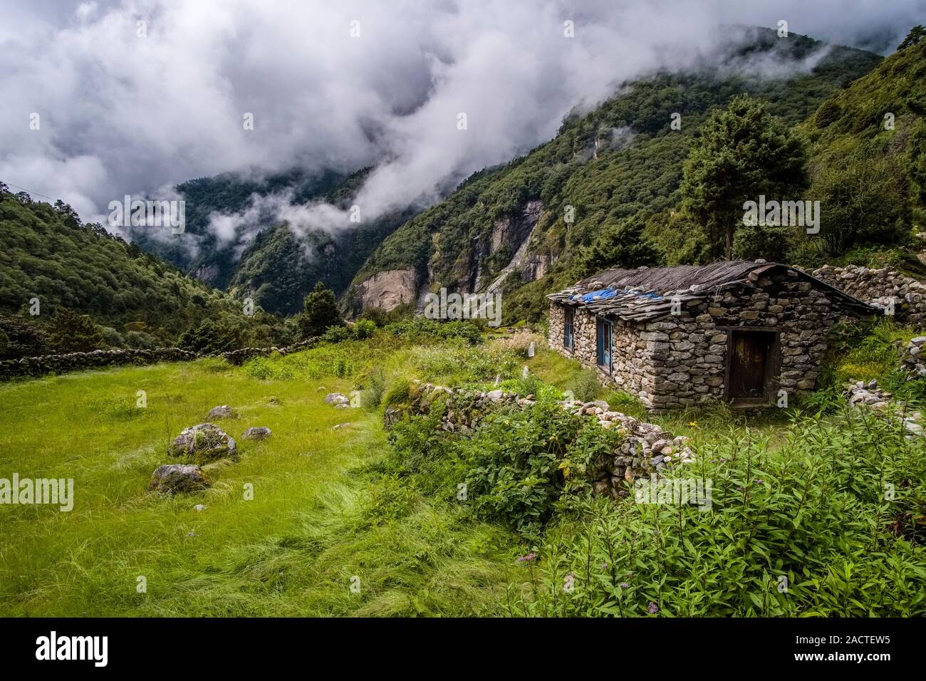 Simple stone house of a small village, mountainous landscape covered in ...