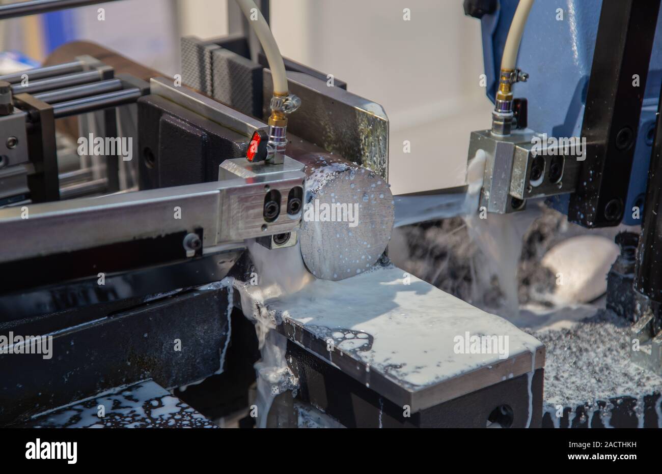 Band saw machine cutting metal rod and cooling with coolant Stock Photo ...