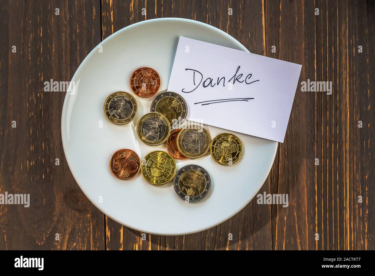 Plate with coins Stock Photo - Alamy