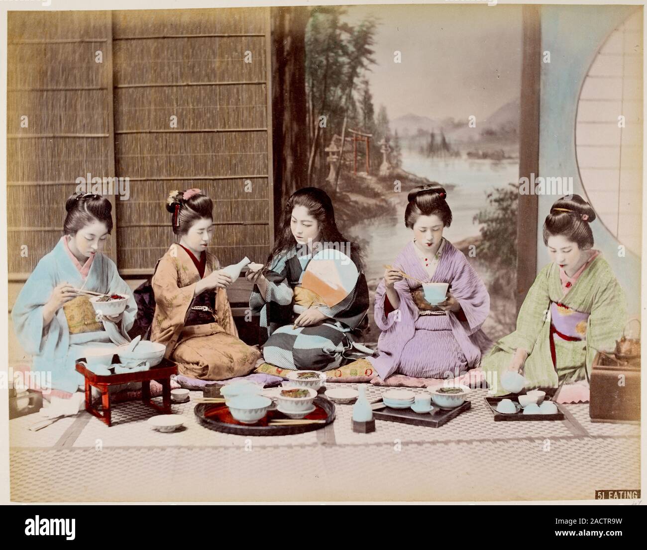 A group of Japanese women eating a meal in a traditional house. Wearing ...