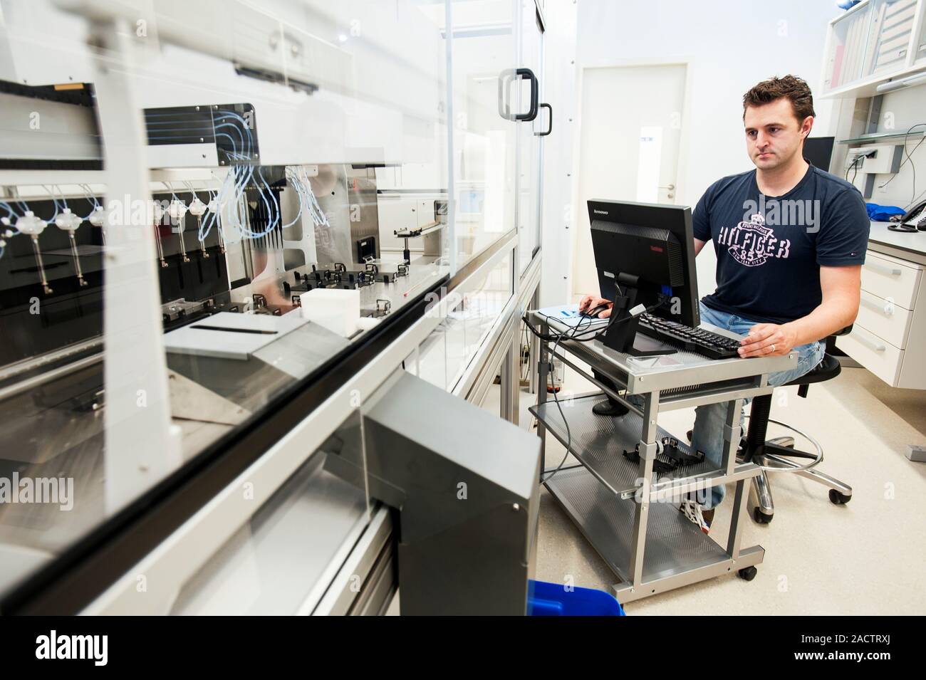 Genetic analysis. Analyst in a genetics laboratory preparing samples at ...