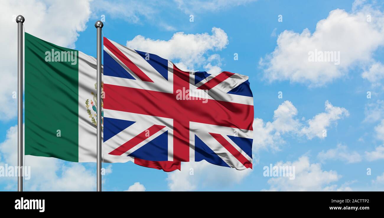 Mexico and United Kingdom flag waving in the wind against white cloudy ...