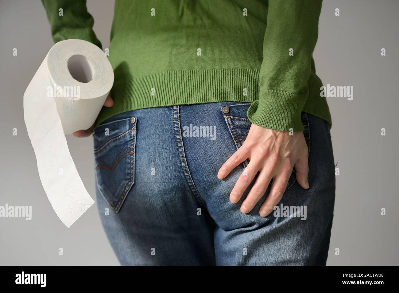 Woman Hand Holding Her Bottom And Toilet Paper Roll Stock Photo - Alamy