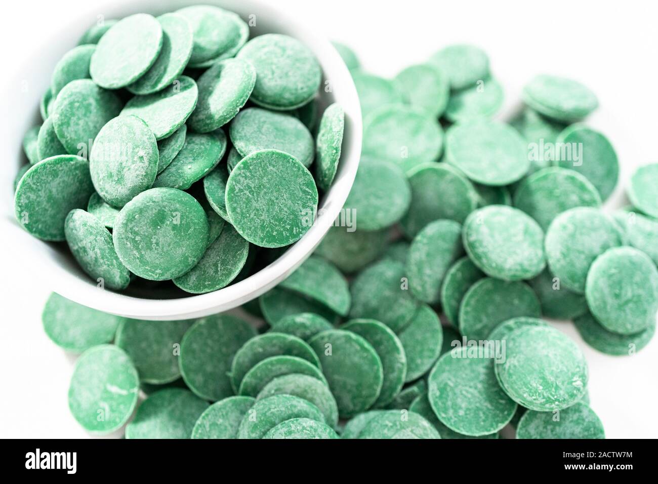 Green round chocolate chips for melting chocolate shapes on a white ...