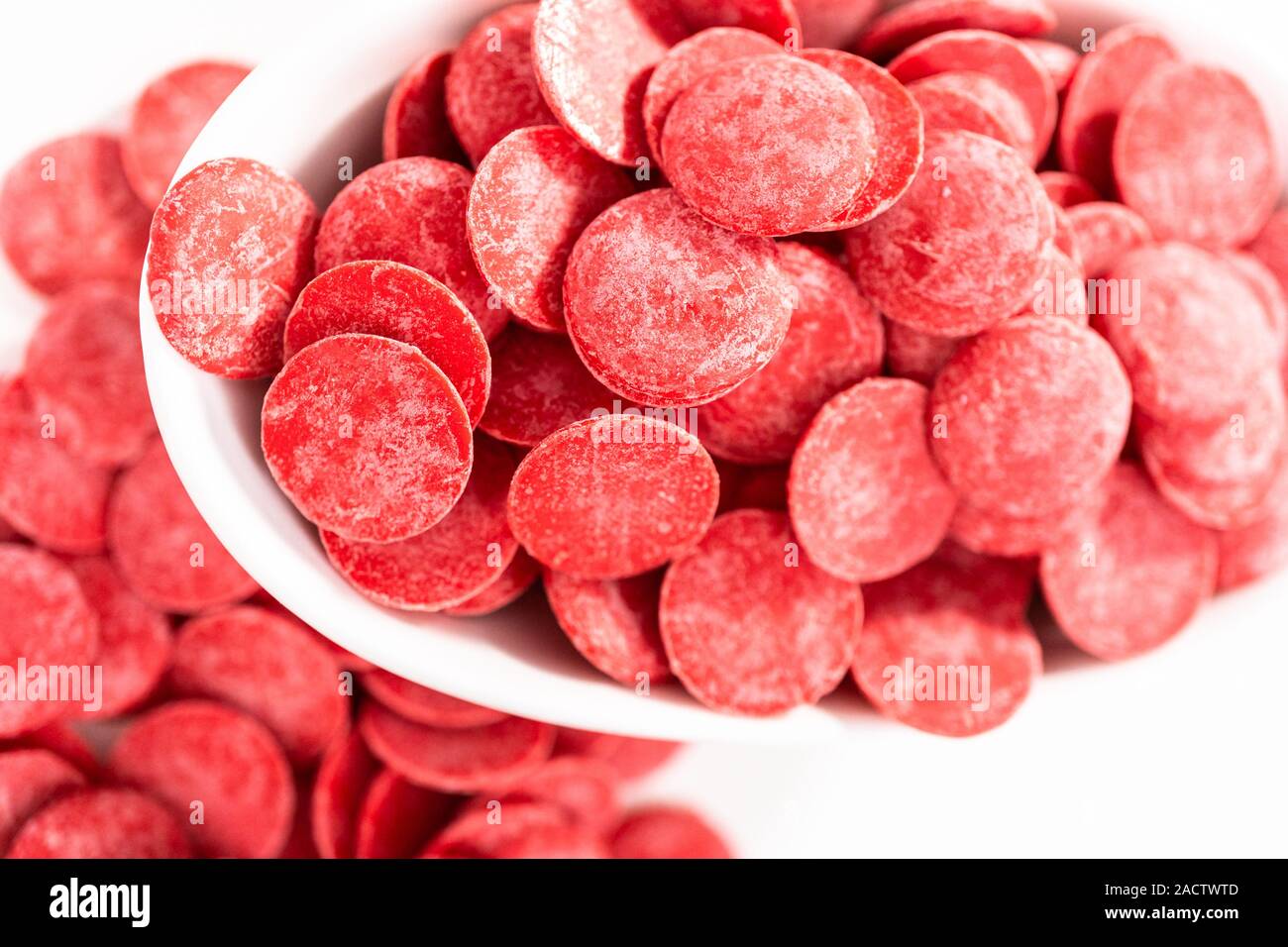 Red round chocolate chips for melting chocolate shapes on a white ...