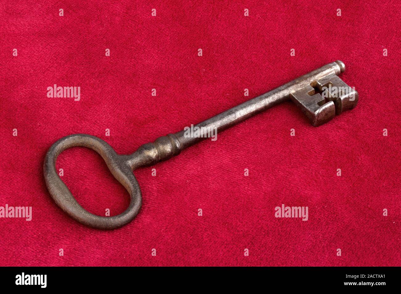 Key on red velvet cushion Stock Photo - Alamy