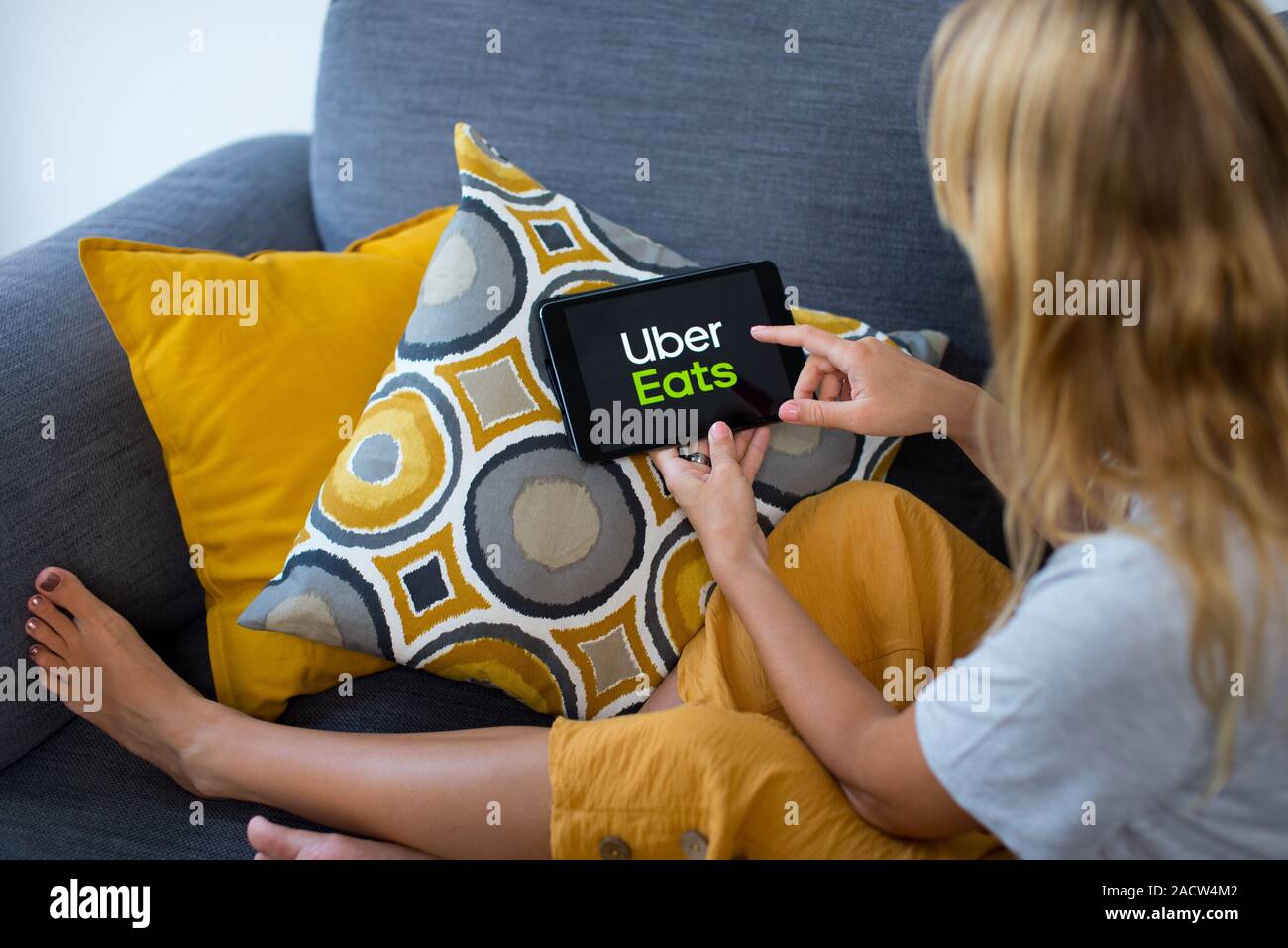 Close up on woman's hands holding smartphone with UberEats logo. Young ...