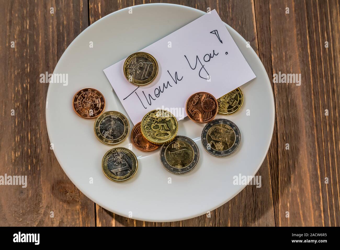 Plate with coins Stock Photo - Alamy
