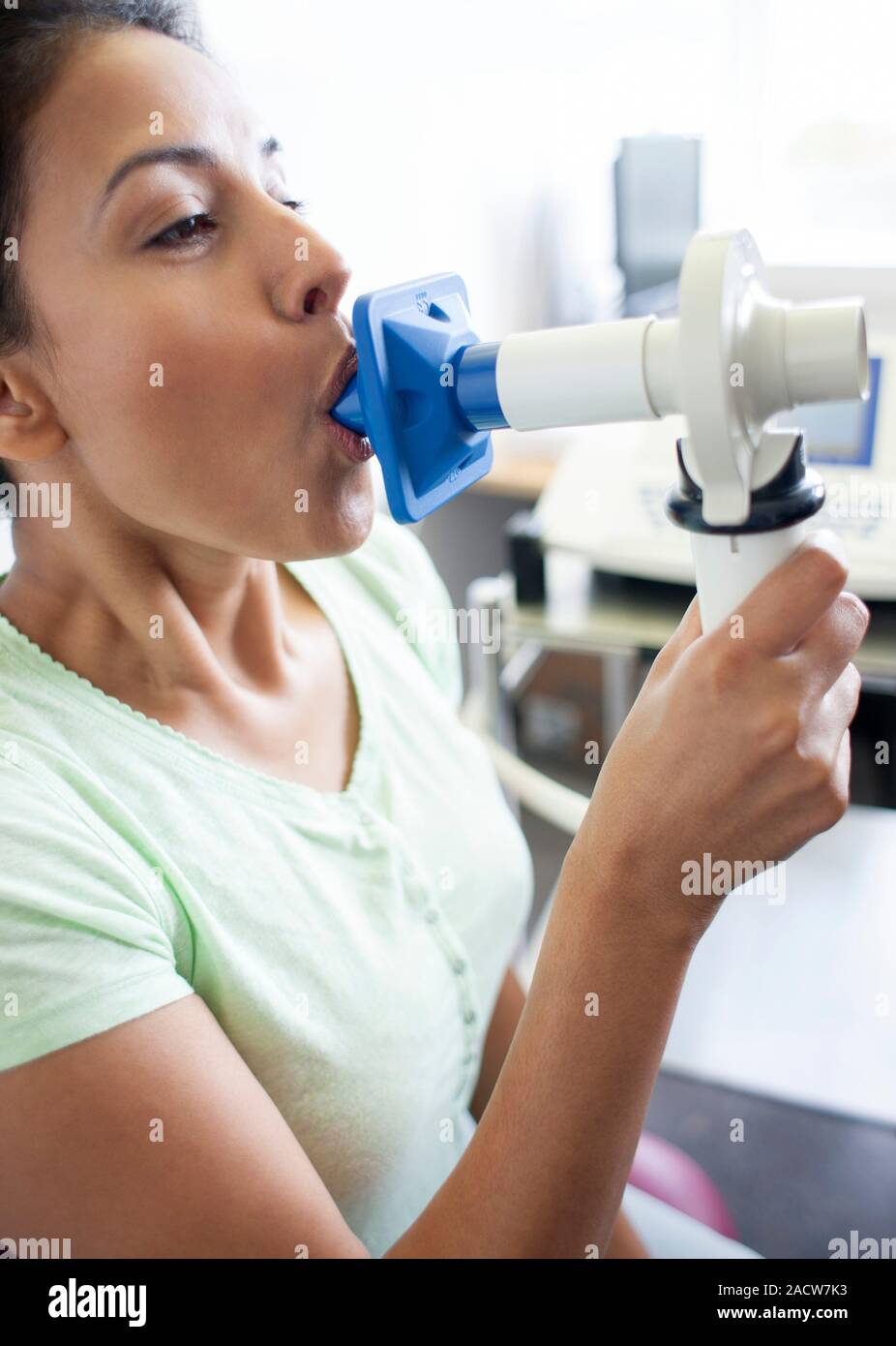 Lung function test. Patient blowing into a peak flow spirometer during ...