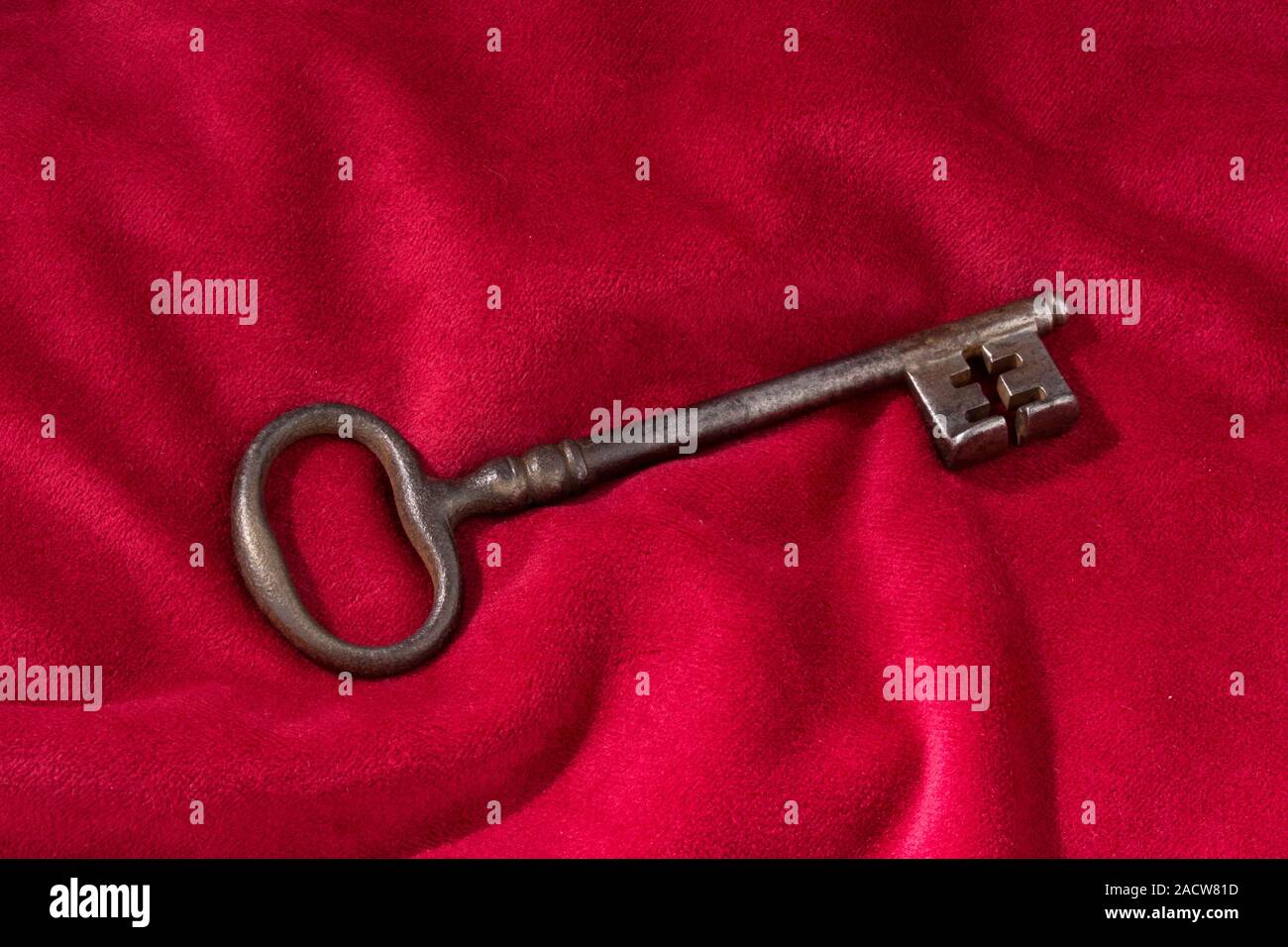 Key on red velvet cushion Stock Photo - Alamy