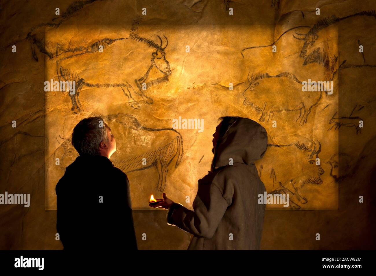 Prehistoric cave paintings. Palaeontologists looking at prehistoric ...