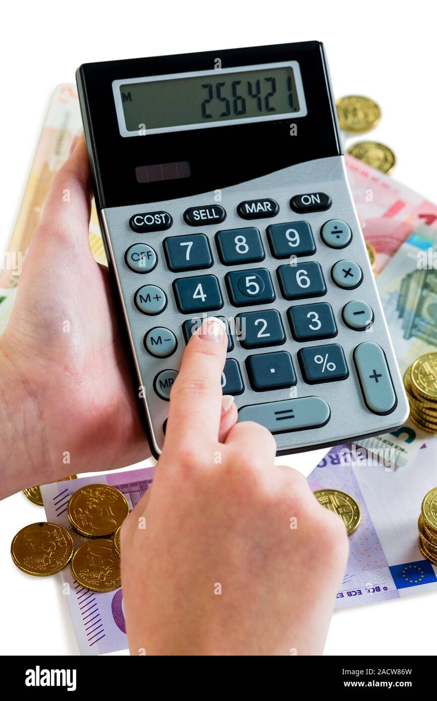 Hand with calculator and money Stock Photo - Alamy