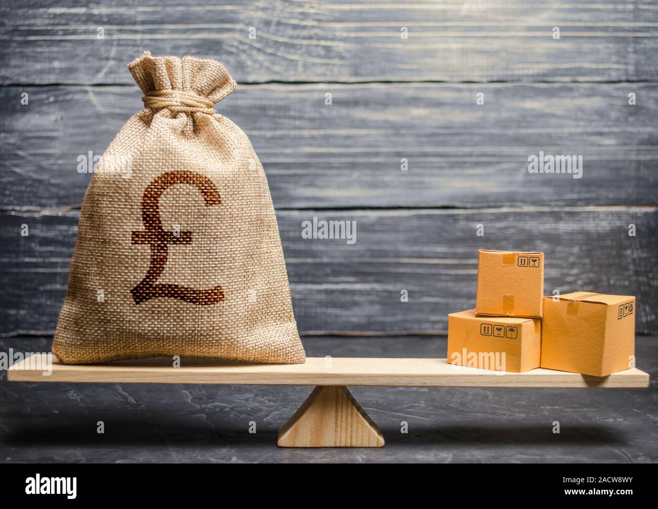 Pound sterling GBP symbol money bag and a bunch of boxes on scales ...