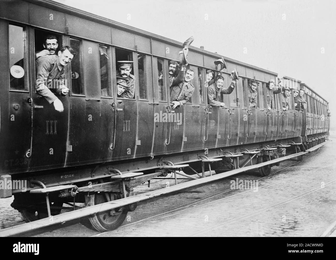 British soldiers leaning out the windows of a travelling train ...