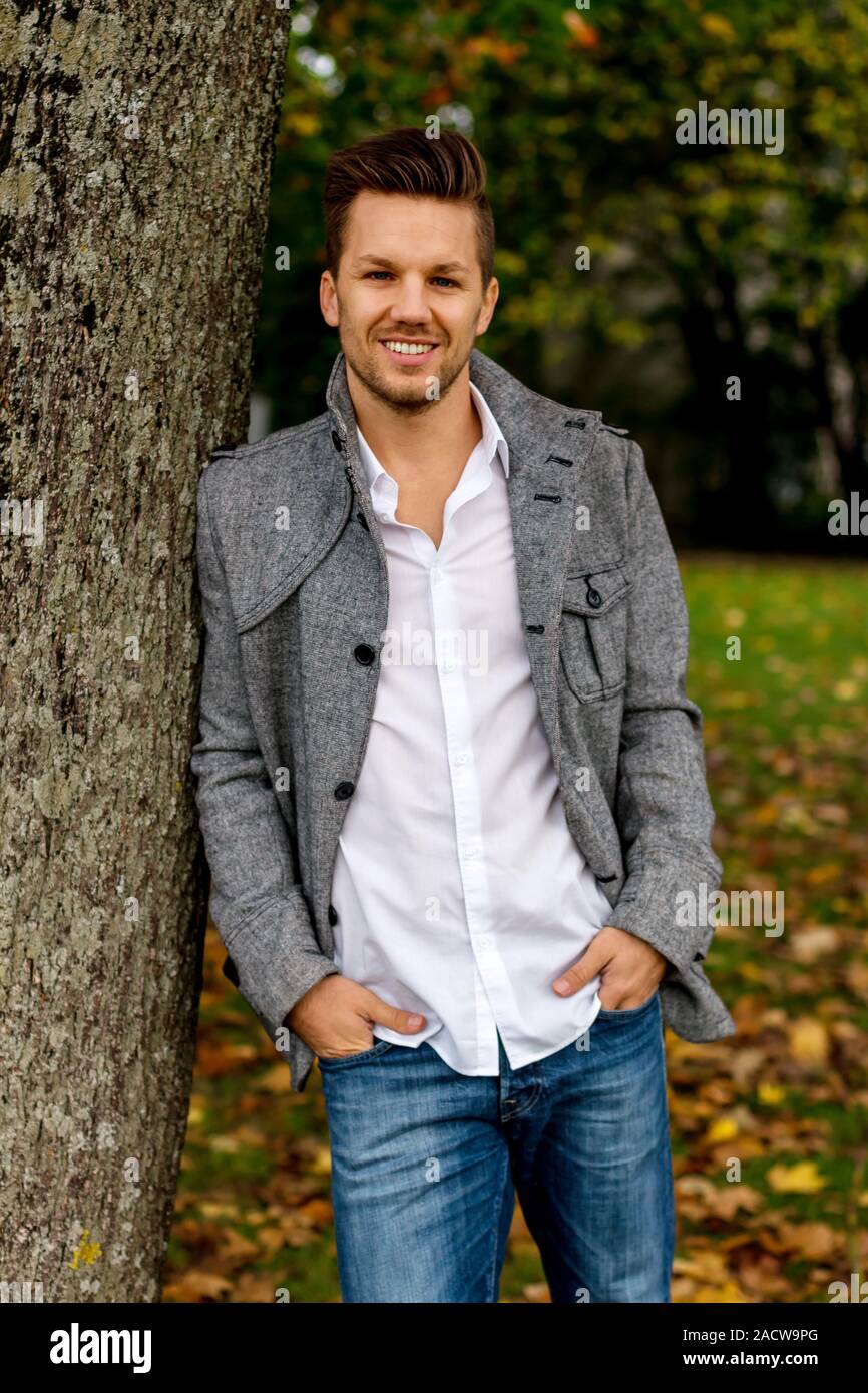 Man leaning against tree Stock Photo - Alamy
