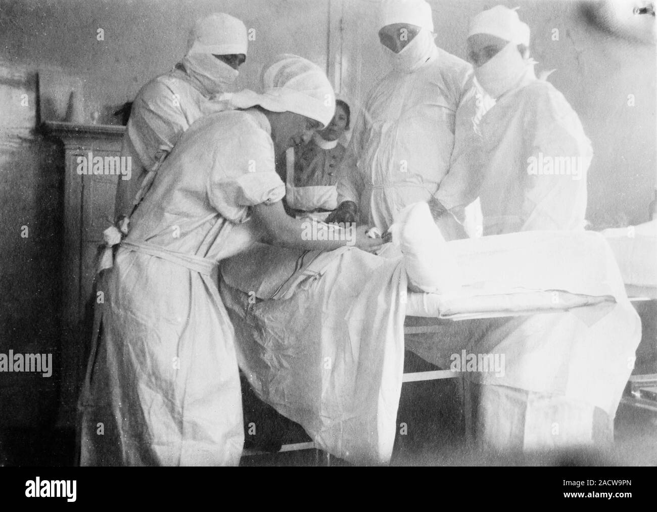 Amputation surgery. Surgical team amputating a soldier's foot at the ...