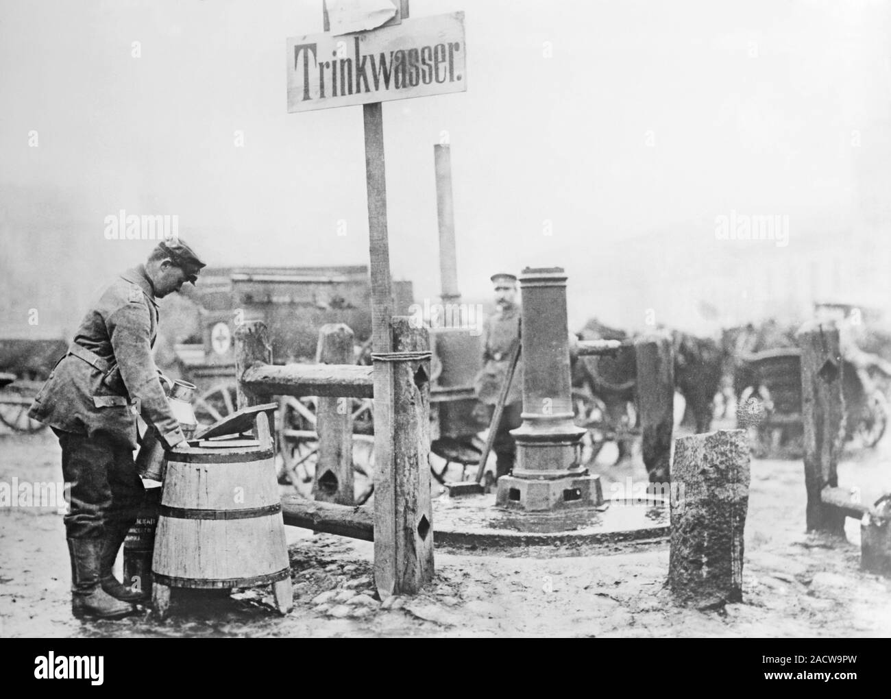 German soldier collecting drinking water from a pump. Photographed in ...