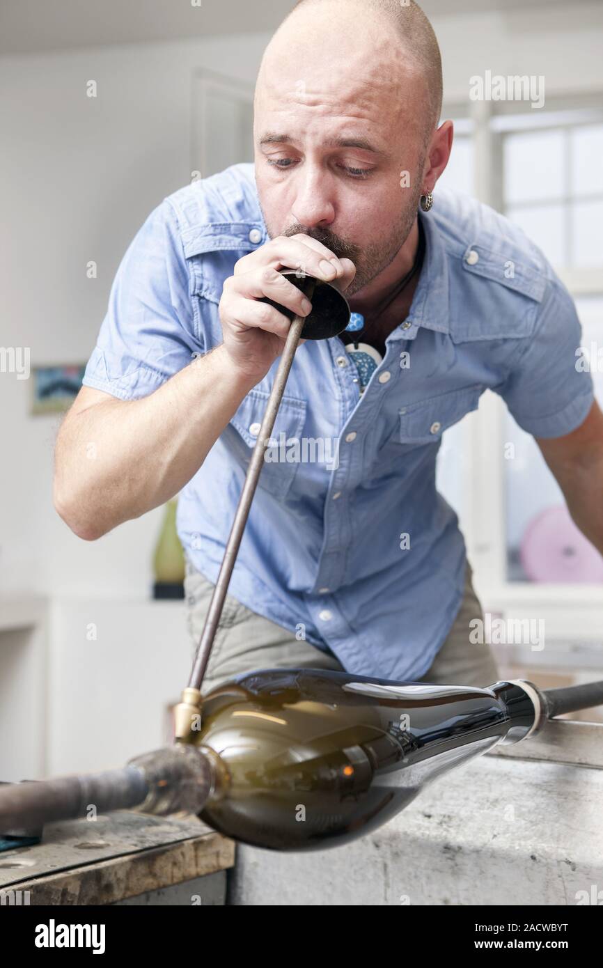 Glassblower at work. He is using a smaller, separate blowpipe (sofietta ...