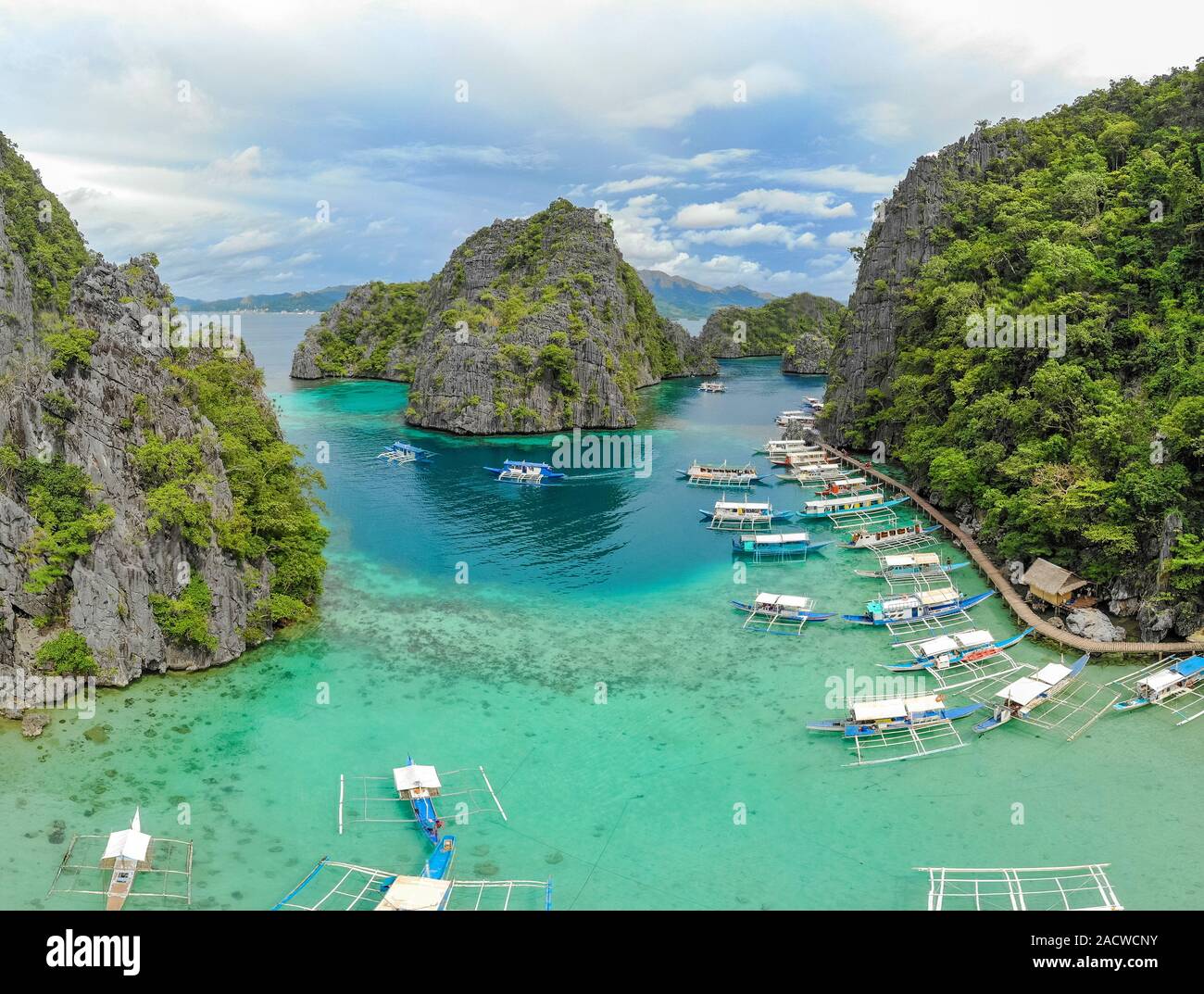 Blue crystal water in paradise Bay with boats on the wooden pier at ...