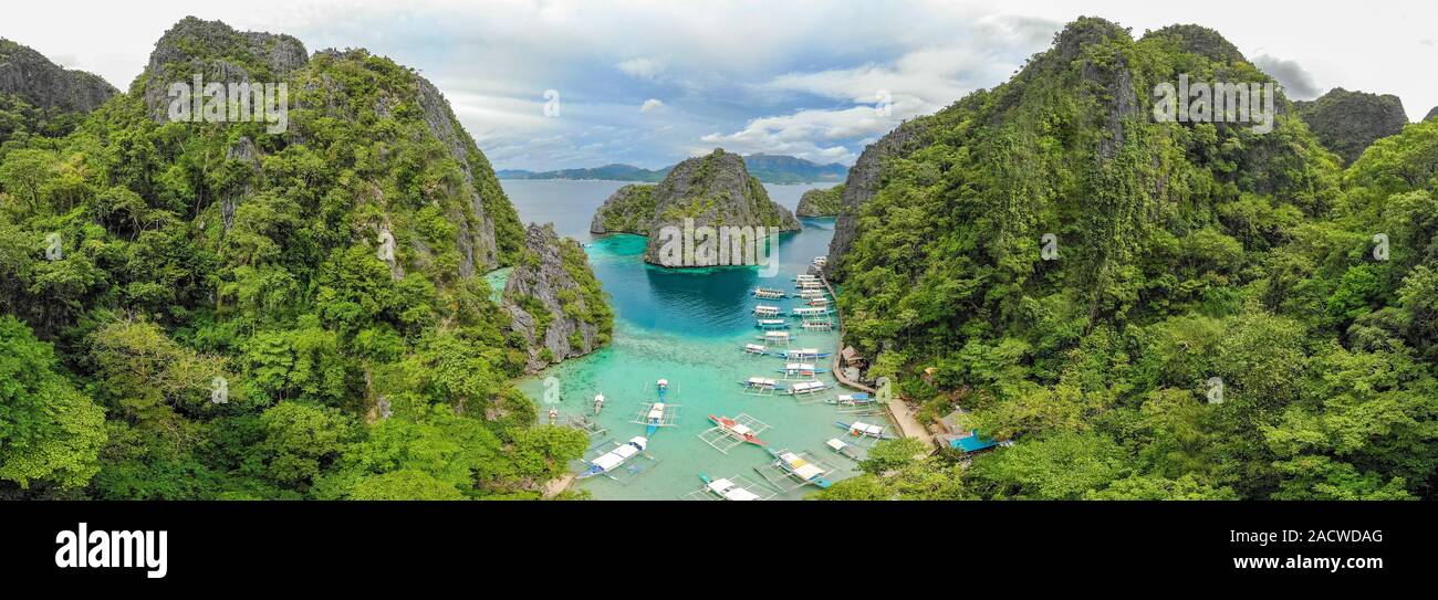 Blue crystal water in paradise Bay with boats on the wooden pier at ...