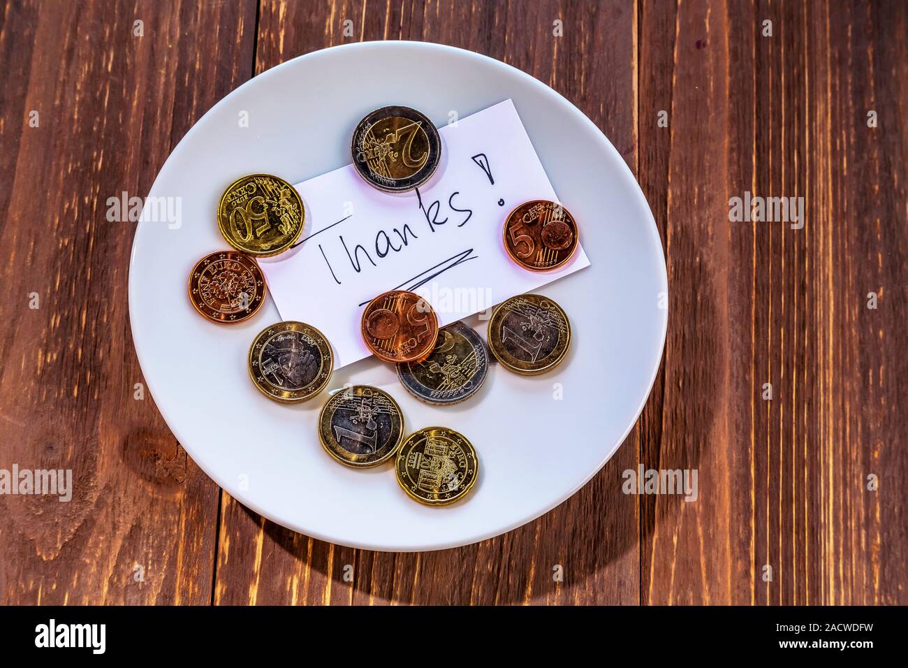 Plate with coins Stock Photo - Alamy