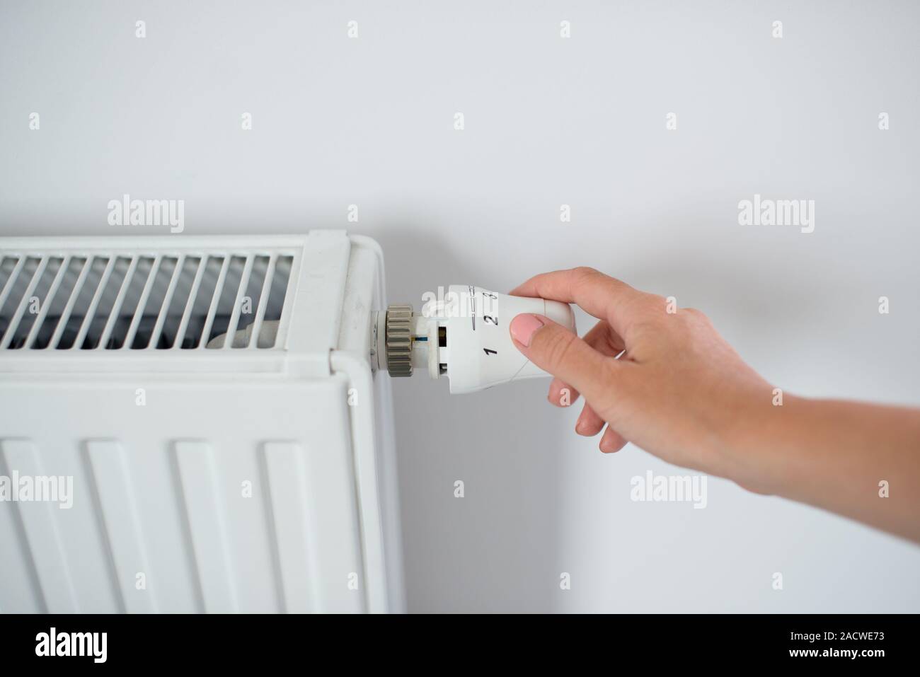 Woman Hand Adjusting The Knob Of Heating Radiator. The valve from the ...