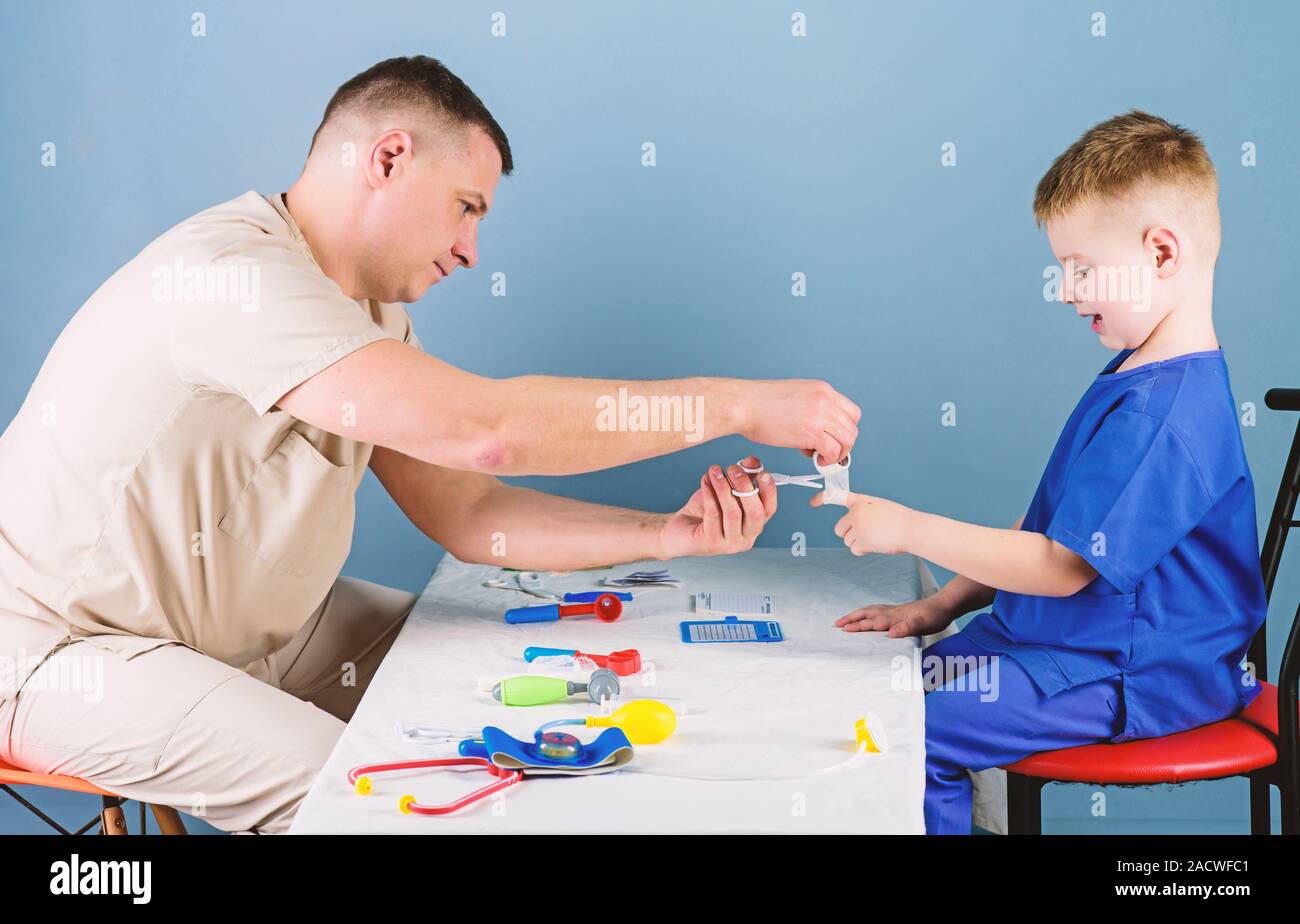 Man doctor sit table medical tools examining little boy patient ...
