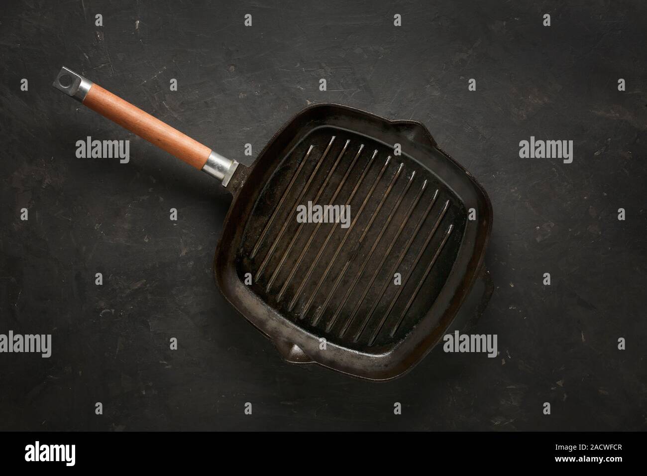 Cast-iron frying pan grill on dark concrete. BBQ concept Stock Photo ...