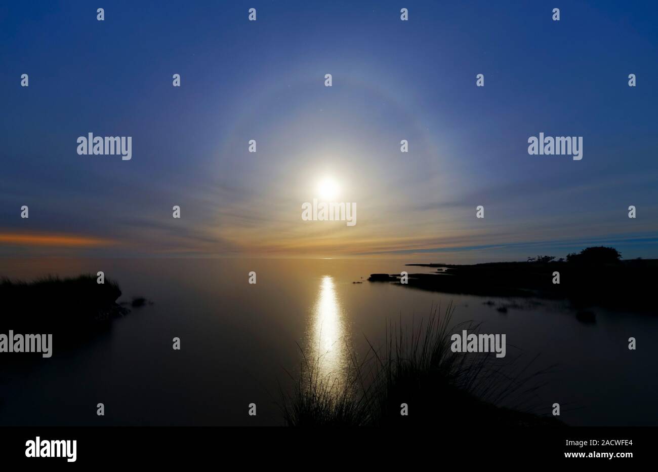 Lunar halo over water, in the sky around the Moon. Lunar halos are an ...