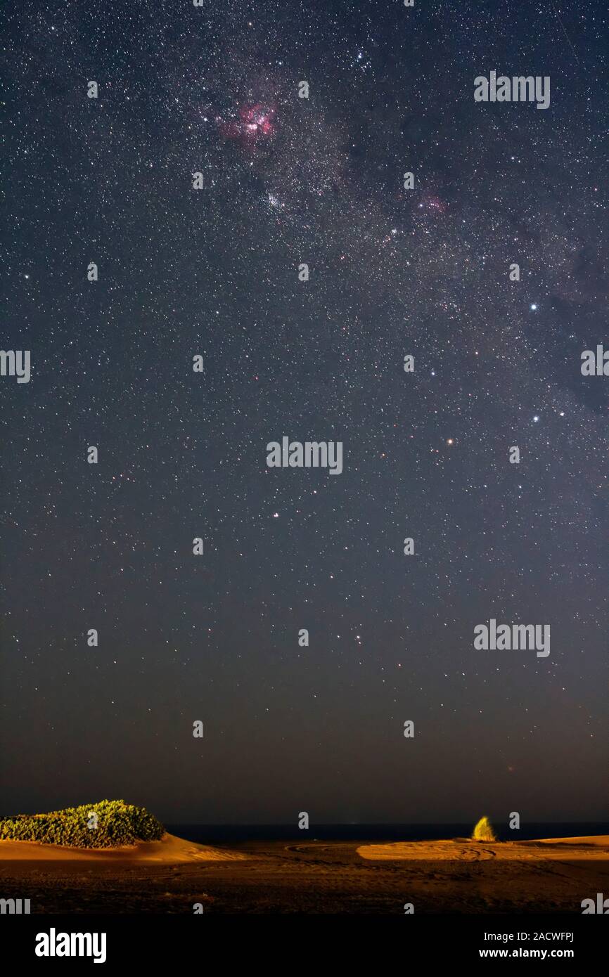 Eta Carina nebula over a beach. The nebula (pink, top centre) forms ...